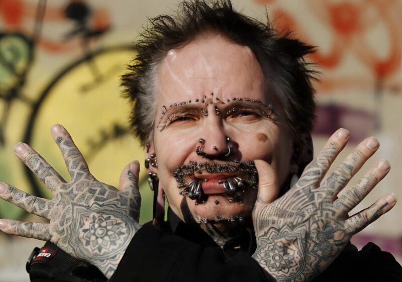A man with 560 piercings, countless tattoos, and forehead implants ...